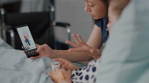 온라인 화상 통화 회의 원격 회의 중에 아픈 딸 옆에 앉아 있는 어머니 3 명에 대한 스톡 사진 및 기타 이미지 3 명 Brand Name Smart Phone 건강