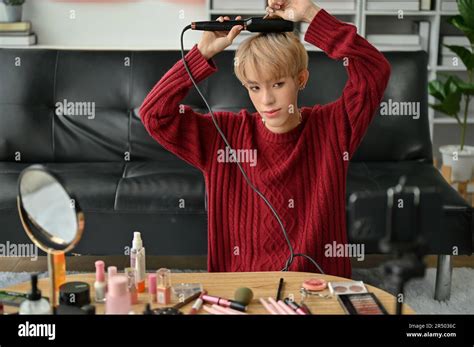 An Attractive Young Asian Gay Beauty Influencer Using A Straightener To