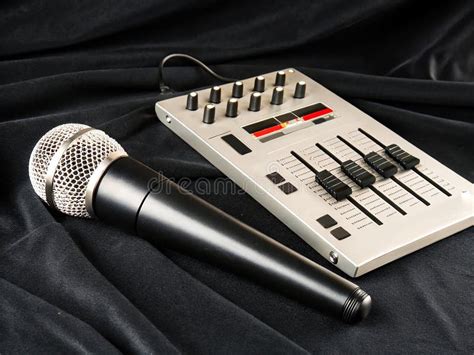 Black Wireless Microphone And Sound Equalizer Placed On A Black Cloth Ready For Use In Acting