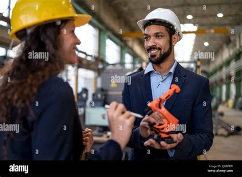 Man Engineer Holding Model Of Industrial Robotic Arm And Showing To