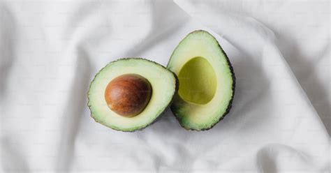 Un Avocat Coupé En Deux Sur Une Feuille Blanche Photo Fosse Photo Sur