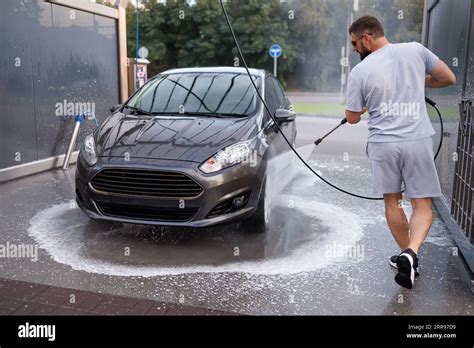 At A Car Wash A Man Washes His Car A Car At A Self Service Car Wash
