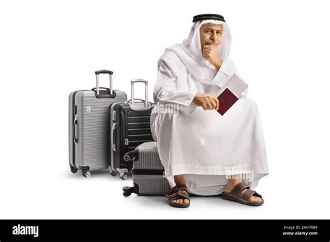 Arab Man Sitting On A Suitcase Holding A Passport And Waiting For A