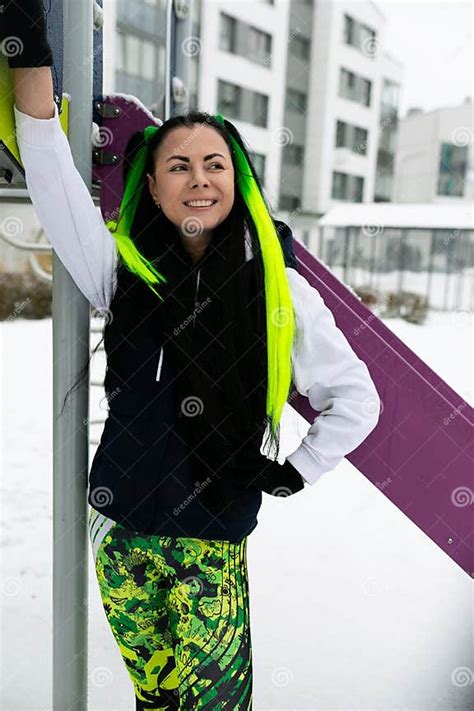 Woman With Green Hair Standing Next To Purple And Pink Slide Stock