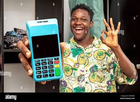 Image Of A Black African Man Standing Excitedly While Holding A Pos Machine Pos Terminal