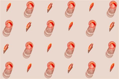 신선한 레모네이드 물 또는 칵테일 한 잔과 파스텔 베이지색 배경에 레드 블러드 오렌지 조각으로 만든 창의적인 패턴 여름 다과