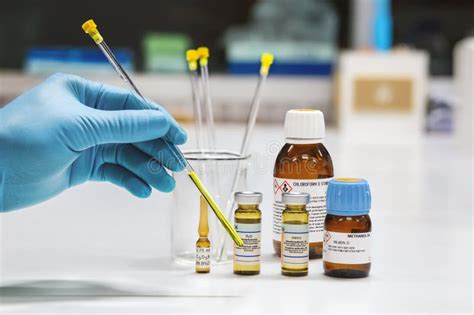 Hand Of The Scientist Shows Yellow Sample Solution And Nmr Solvent