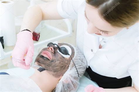 El Cosmetólogo En Guantes Rosados Con Un Cepillo Aplica Una Máscara De