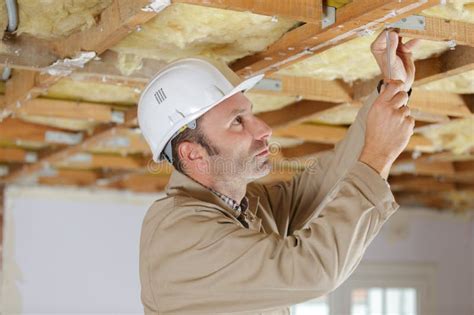 Constructor De Hombres Con Destornillador En El Techo Imagen De Archivo Imagen De Herramienta