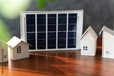 On Desk Of Engineers Lay Model Of House And Solar Panels To Use In Planning Installation Of