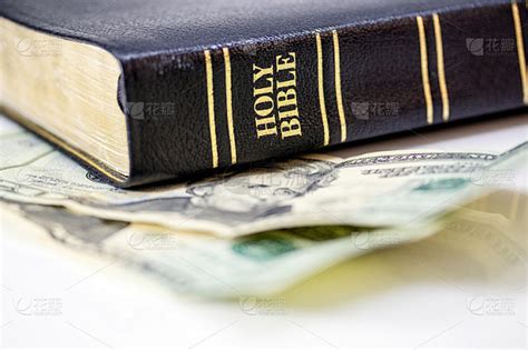 神圣的基督教圣经与金钱隔离在白色