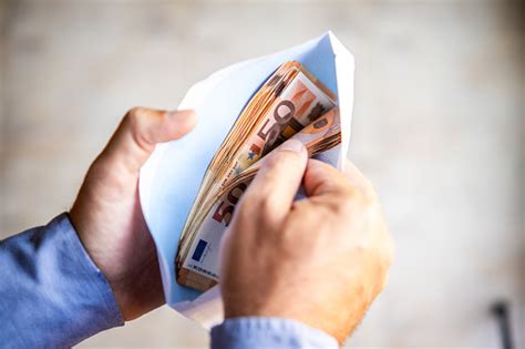 한 남자가 손에 들고 있는 봉투 안에 있는 유로 지폐의 돈을 사기성 출처 검은 돈 또는 B 지불로 봅니다 관점 Pov 탈세에