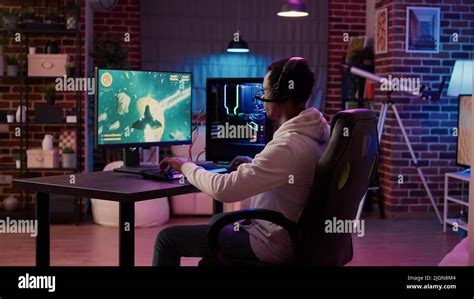 African American Man Playing Fast Paced Multiplayer Space Shooter Using