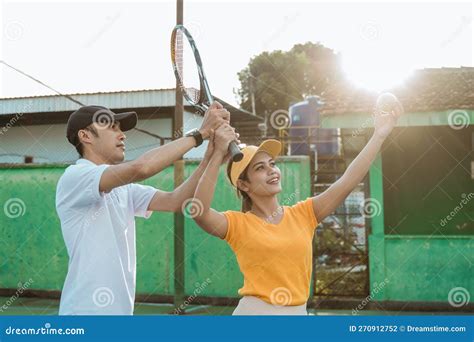 Female Tennis Player Holding Racket And Ball Trained By Coach Stock