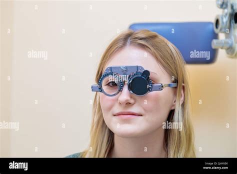A Male Optometrist Checks The Eyesight Of A Young Girl With A Trial