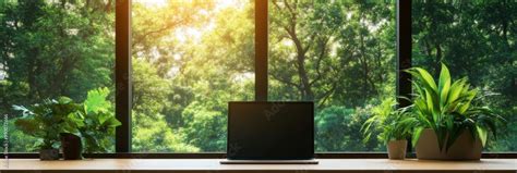 A Modern Office Workspace With Large Windows Offering A Serene View Of Lush Greenery The