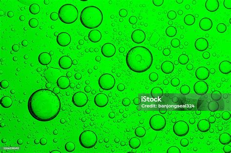 녹색 매크로 거품 질감 밝은 녹색 배경 물에 기름이 떨어지는 근접 촬영 거품이 있는 액체 표면의 추상적인 매크로 사진 구조적인
