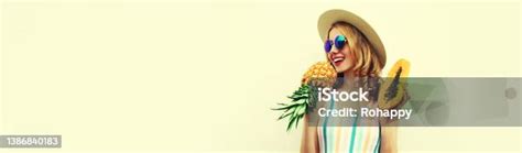 파인애플과 파파야 신선한 열대 육즙이 많은 과일 밀짚 모자를 쓰고 흰색 배경에 선글라스를 쓰고 광고 텍스트를 위한 빈 배너 복사 공간을 가진 행복한 미소 젊은 여성의 여름