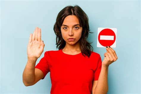 Joven Hispana Sosteniendo Un Cartel Prohibido Aislado De Fondo Azul Foto Premium