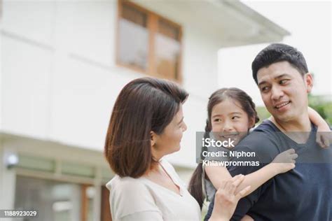 젊은 아시아 가족 사랑 아버지 어머니와 딸 서 놀고 재미 에 야외 에서 집 앞 웃고 있는 어머니를 바라보는 소녀와 아버지 배경은