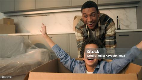 행복 한 아프리카 계 미국인 가족 재배치 축하 새 집 아버지 실행 푸시 골판지 상자 작은 아들 소년 아이 안에 기쁨 미소 아이