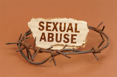 On A Brown Surface Barbed Wire And A Cardboard Sign With The