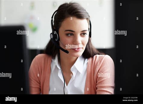Conscientious Young Worker A Pretty Young Woman Wearing A Headset