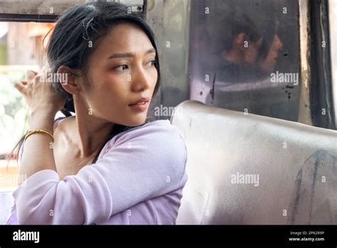 A Young Woman Sits In A Old Bus And Looks Back Through The Rear Window