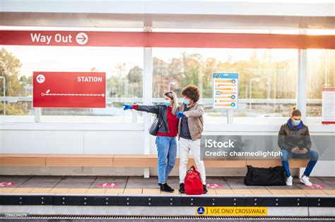 아름다운 부부와 한 남자는 버스가 사회적 거리를 유지하는 버스를 기다리는 기차역에서 보호 얼굴 마스크를 착용 포스트 잠금을 재개