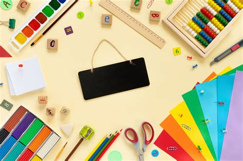 베이지 색 종이 배경에 학교와 사무용품 테두리를 공급합니다 여러 가지 빛깔의 연필 페인트 플라스틱 아바쿠스 푸시 핀 및 기타 학교 액세서리 0명에 대한 스톡 사진 및 기타