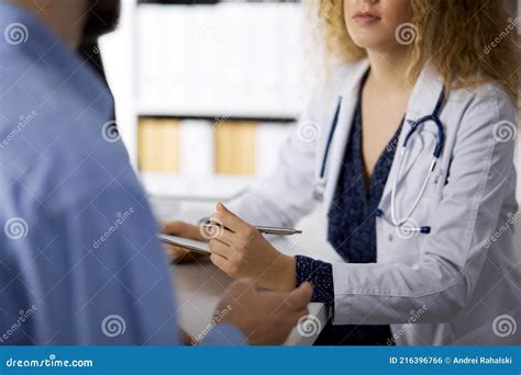 Female Doctor And Male Patient Discussing Current Health Examination