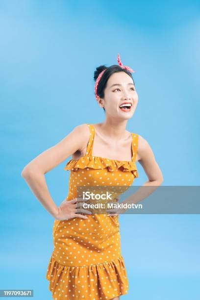 파란색 배경에 서 물방울 무늬 드레스를 입고 포즈를 취하는 매력적인 여성 핀 업 스타일 감정에 대한 스톡 사진 및 기타 이미지 감정 나이 놀라움 Istock