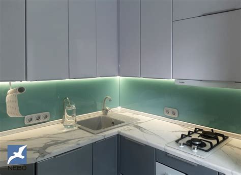 Стеклянный фартук синевато зеленого цвета для рабочей зоны кухни со столешницей под белый мрамор