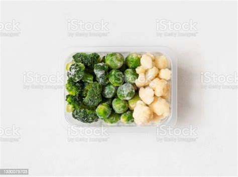 냉동 야채 양배추 세트 브로콜리 브뤼셀 콩나물 콜리플라워가 흰색 배경에 있는 용기에 들어있습니다 상단 보기 플랫 레이 방울