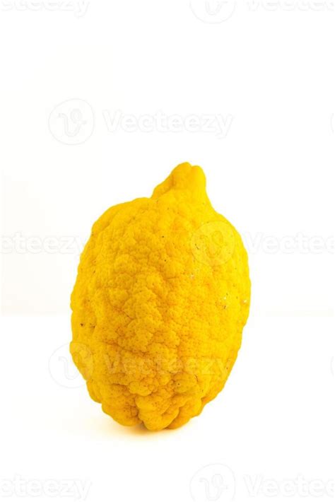 A Large Rough Textured Lemon Sits Against A Plain White Background Its Bumpy Surface And
