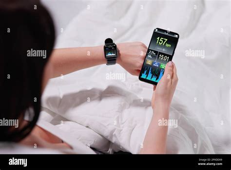 Woman S Hand With Smartwatch And Cellphone Monitoring Heart Rate Stock Photo Alamy