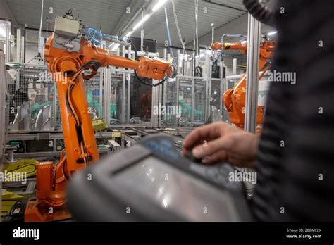 man programming robot in automotive industrial professional programmer