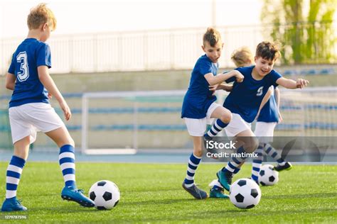 축구 게임을 하는 학교 소년 스포츠 잔디 피치에 축구 공을 걷어 차는 젊은 선수 행복한 아이들은 필드에서 경쟁 10 11세에 대한 스톡 사진 및 기타 이미지 Istock