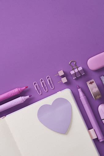 열린 메모장 하트 모양의 스티커 및 문구류가있는 미니멀리즘 파스텔 문구류 플랫 레이 라일락 배경에 펠트 팁 펜 펜 종이 클립 클립 보드 및 지우개 텍스트를 위한 위치입니다