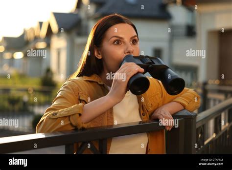 Concept Of Private Life Curious Young Woman With Binoculars Spying On Neighbours Over Fence