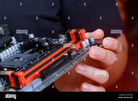 The Engineer Installing Memory RAM On Motherboard Computer In Computer Lab Installing Computer