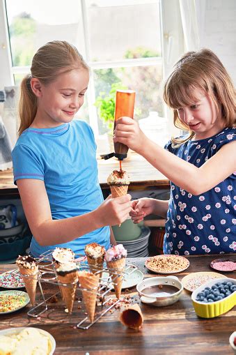 다양한 토핑 과일 사탕 스프링클러와 콘에서 아이스크림을 준비하는 어린 소녀 아이스크림 콘에 대한 스톡 사진 및 기타 이미지 아이스크림 콘 10 11세 2명 Istock