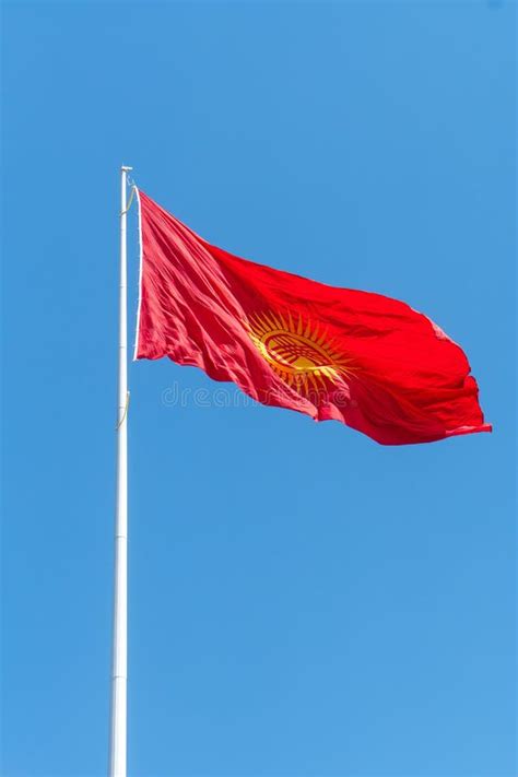 Red Kyrgyzstan Flag With Yellow Sun Emblem Fluttering High Above Ala