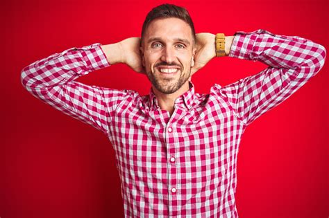 젊은 잘 생긴 남자 위에 빨간 고립 된 배경 휴식과 스트레칭 팔과 손 뒤에 머리와 목 행복 미소 긍정적인 감정 표현에 대한 스톡 사진 및 기타 이미지 Istock