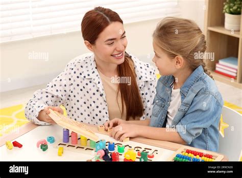 Happy Mother And Daughter Playing With Different Math Game Kits At Desk