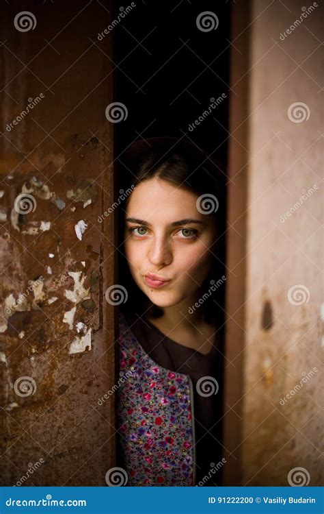 Una Giovane Ragazza Curiosa Guarda Fuori Da Dietro La Porta Della Sua