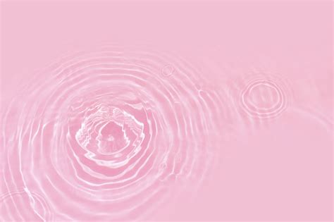 디포커스는 투명한 핑크색의 맑고 잔잔한 물 표면 질감을 스플래쉬 버블로 흐리게 처리했습니다 빛나는 분홍색 물 잔물결 배경 수영장에서 물의 표면 분홍색 거품 물이 빛나고