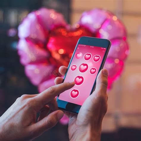 Hand Holding A Smartphone Displaying A Valentines Day Themed App