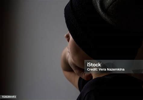 戴著帽子的少年 站在黑暗的房間裡 把目光移開 從窗戶發出的光 照片檔及更多 人 照片 人 人的眼睛 人的頭部 Istock