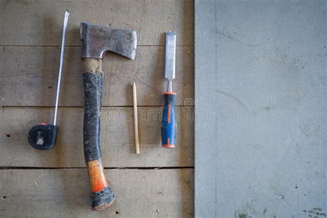 Construction Tools Such As An Axe Chisel Tape Measure And Pencil On A